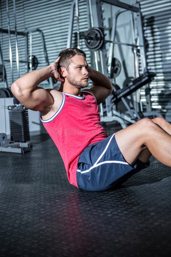 Muscular man doing sit-ups stock photo. Image of exercising - 56494884