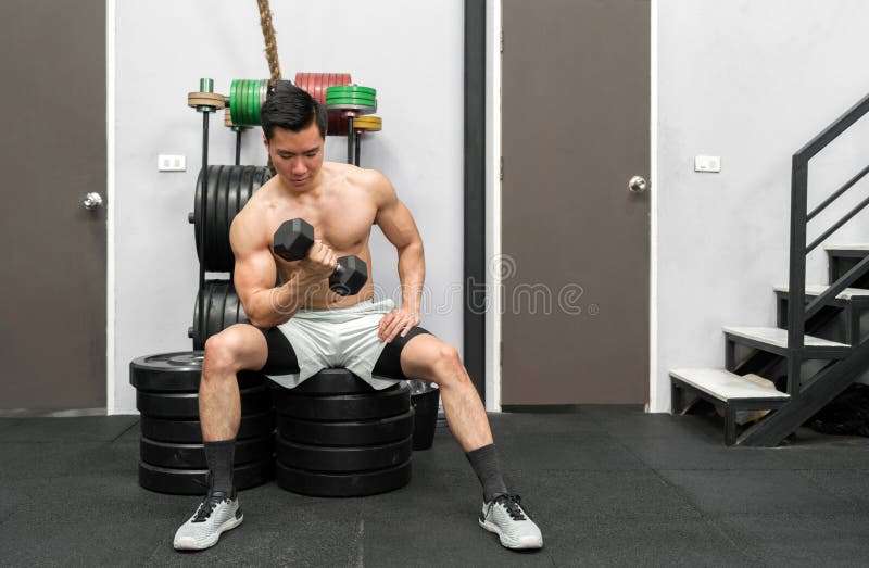 A Muscular Man Energetically Performs a Strength-training Exercise in a ...