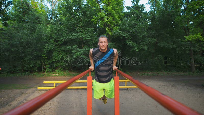 Muscular Man during His Workout in Park. Dips, Exercise Chest and ...