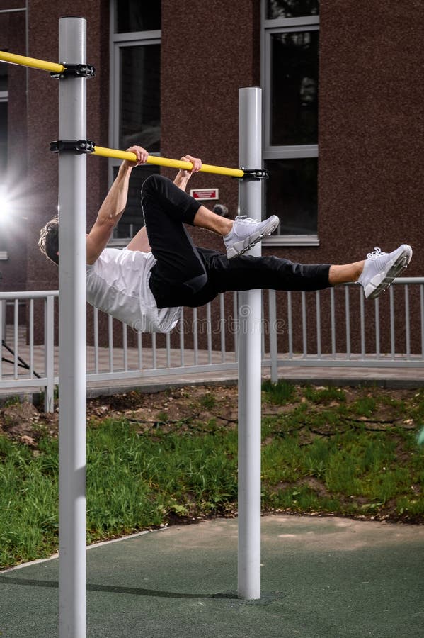 Muscular Man during His Workout on the Street with Horizontal Bar Stock ...
