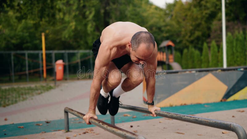 Muscular Man Performing Dips on Parallel Bars in a Park Stock Video ...