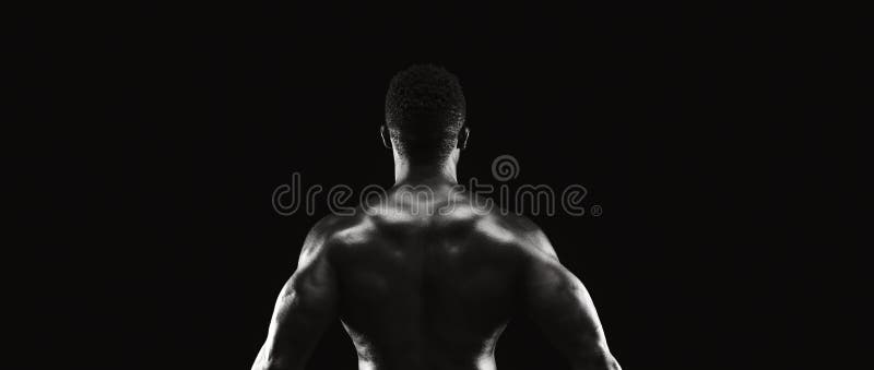 Muscular Man Standing Backwards in Dark Studio Stock Photo - Image of ...