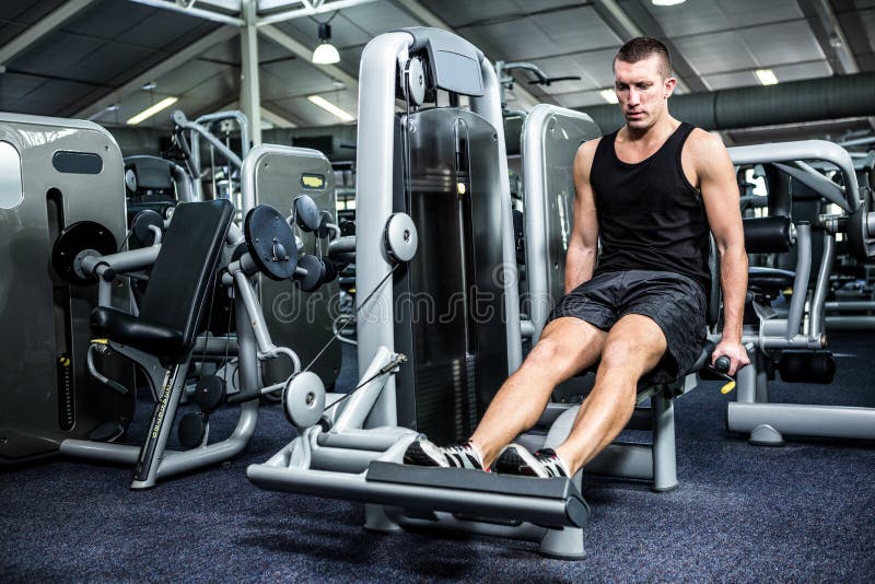 Muscular Man Using Exercise Machine for Legs Stock Image - Image of ...