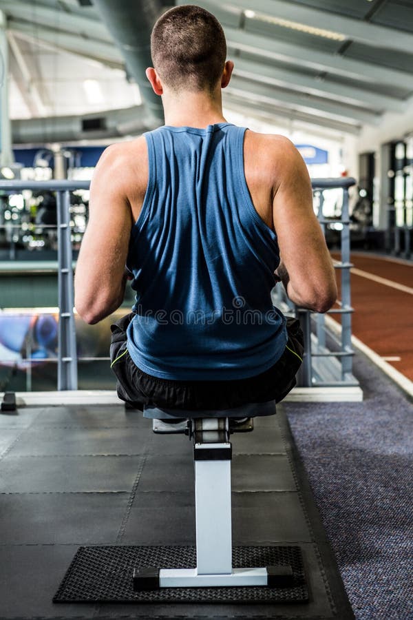 Muscular Man Using Rowing Machine Stock Photo - Image of rowing, sports ...