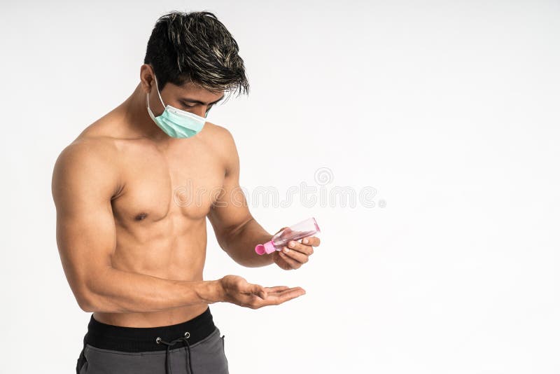 Muscular Man Wearing a Mask with a Pose is Using a Hand Sanitizer Stock ...