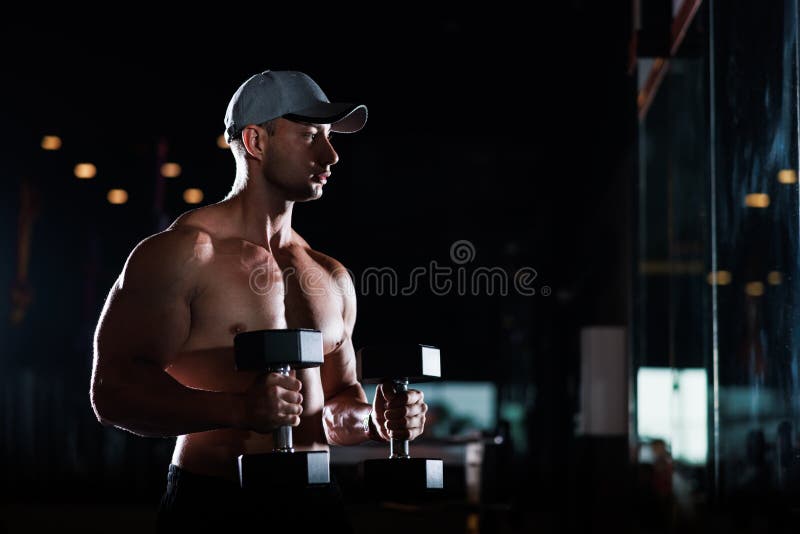 Muscular Man Working Out with Dumbbells in Gym Dark Tone Stock Image ...