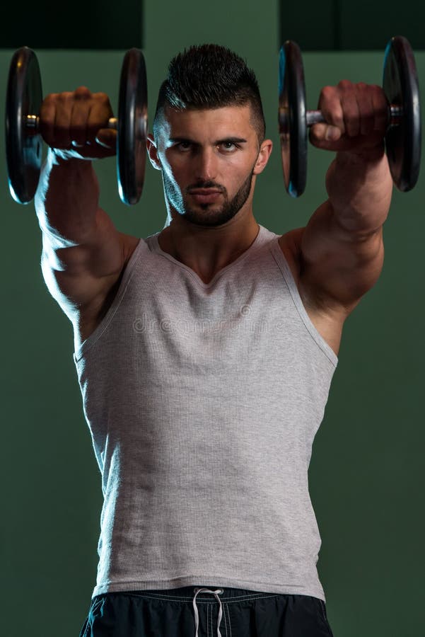 Muscular Men Exercising Shoulder with Dumbbells Stock Photo - Image of ...