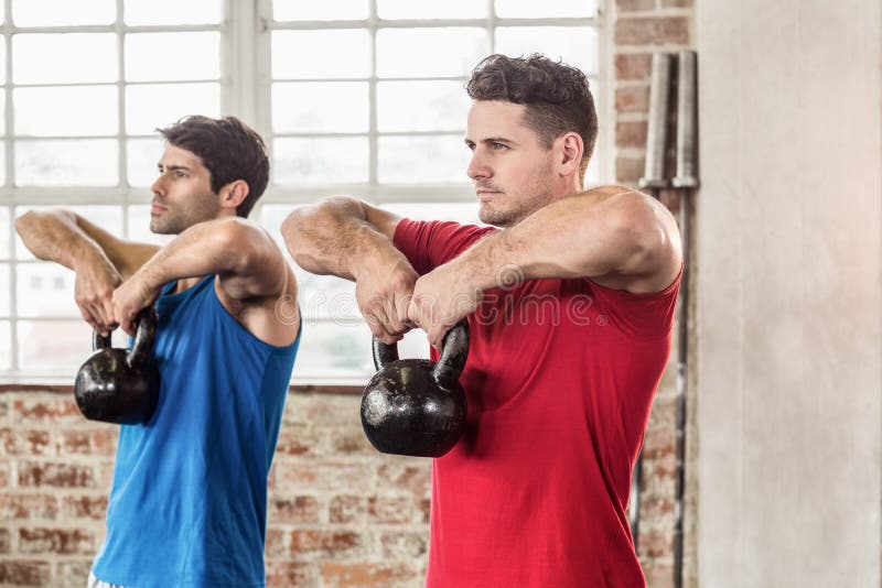 Muscular Men Lifting a Kettle Bell Stock Photo - Image of attentively ...