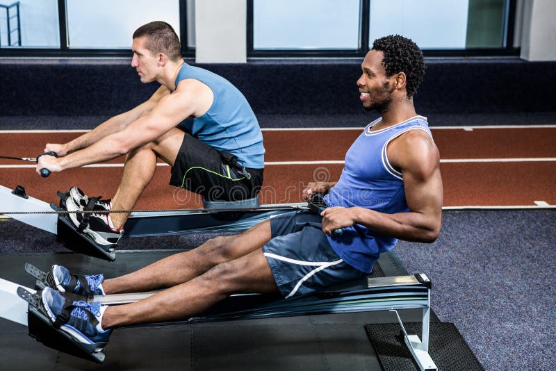 Muscular Men Using Rowing Machine Stock Photo - Image of male, healthy ...