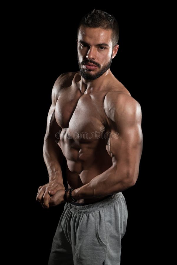 Muscular Model Flexing Muscles on Black Background Stock Photo - Image ...