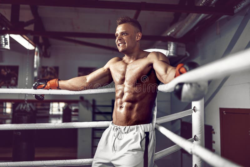Muscular Professional Kick Boxer Resting on the Ropes in the Corner of ...