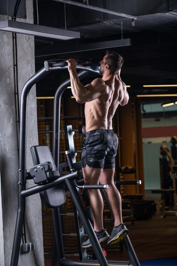 Muscular Young Man Doing Exercise for the Back on Horizontal Bar Stock ...