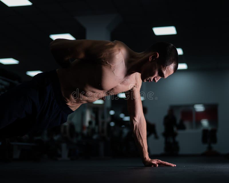Muscular Shirtless Man Doing One-arm Push-ups in the Gym. Stock Photo ...