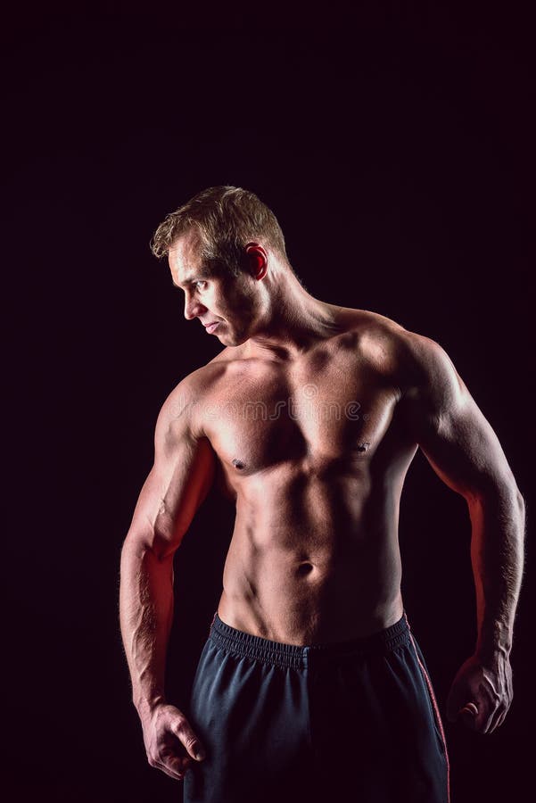 Handsome Power Athletic Man in Training Pumping Up Muscles with ...