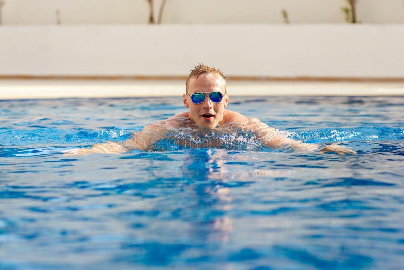 Muscular Young Man in Blue Glasses Floating in the Pool Stock Photo ...