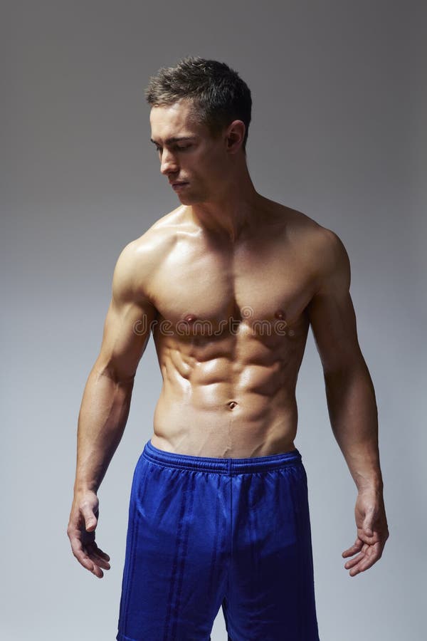 Muscular Young Man Flexing Arm Muscles in Sports Outfit Stock Image ...