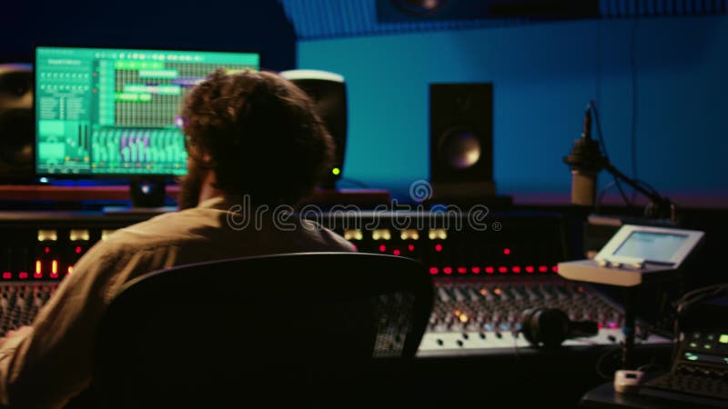 Music Producer Editing Tracks with Mixing Console and Audio Software in ...