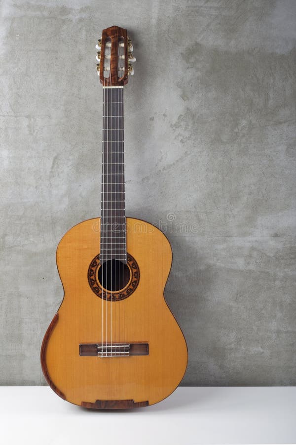 Musical Instrument - Classical Guitar Stands Against a Concrete Wall on ...