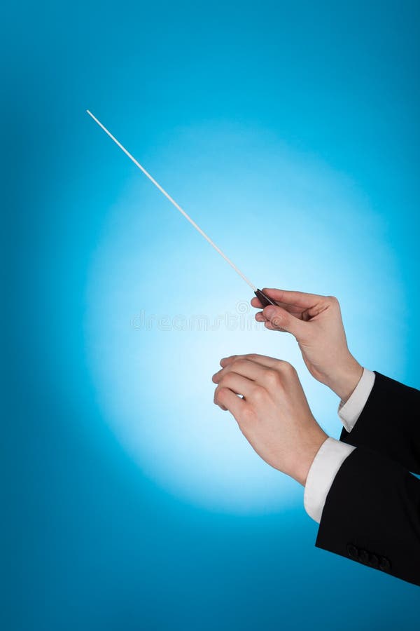Musician Holding Baton Against Blue Background Stock Photos - Free ...