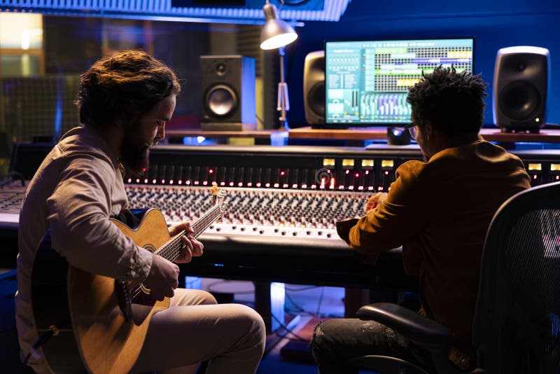 Musician Records Electro Acoustic Guitar Sounds with Technician in ...