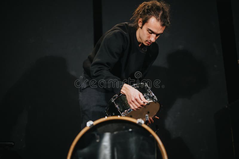 Young Musician Assembling a Drum Set during Sound Check on a Dark Stage ...