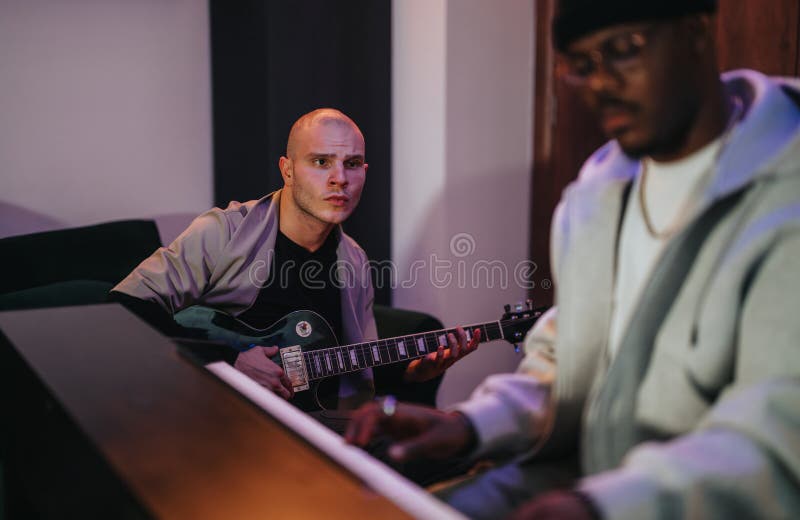 Musicians Collaborating in a Cozy Studio Setting with Guitar and Piano ...