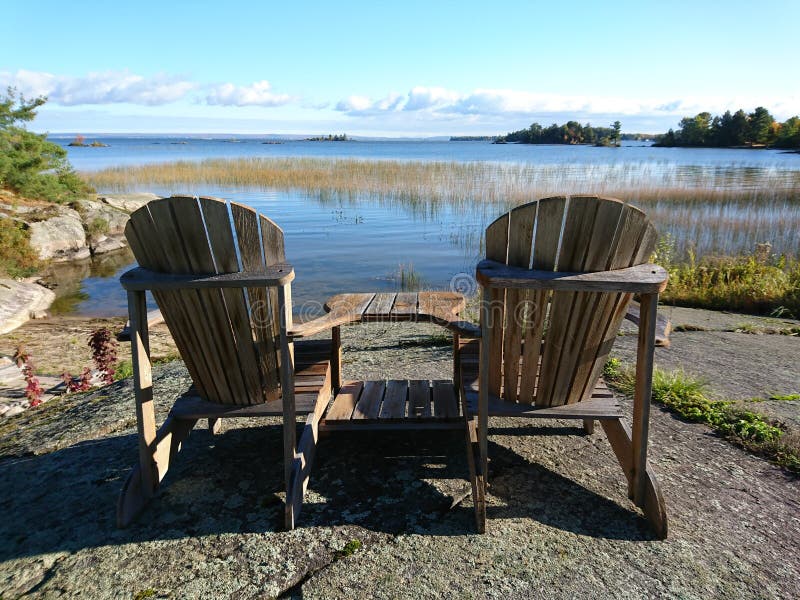Muskoka Chairs Sitting At The End Of A Dock In Front Of Lake Joseph At ... Muskoka Chairs Sitting At The End Of A Dock In Front Of Lake Joseph At ...