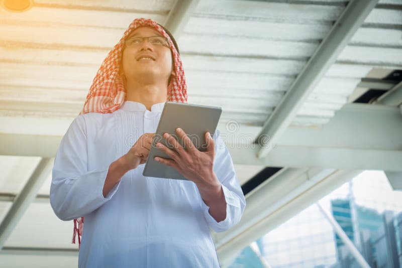 Muslim Arab Man and Smart Phone.he is Using Tablet Pc Computer and ...
