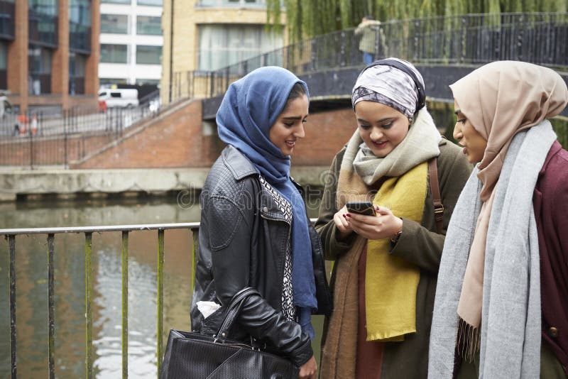 Muslim Female Friends Using Mobile Phone in Urban Setting Stock Image ...