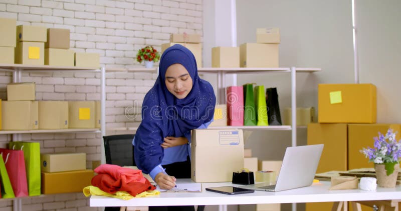 Muslim Female Merchandiser Preparing Parcel at the Office Stock Photo ...