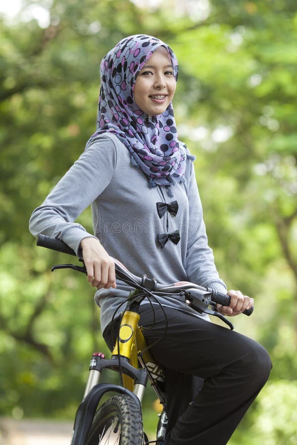 Muslim girl on bicycle stock photo. Image of adult, islam - 38359160