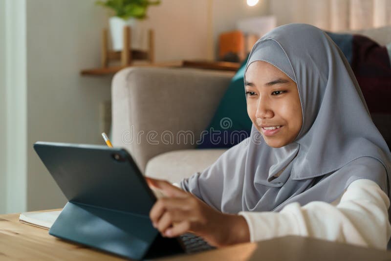 Muslim Girl Learning Online Via the Internet Tutor on a Laptop Computer ...