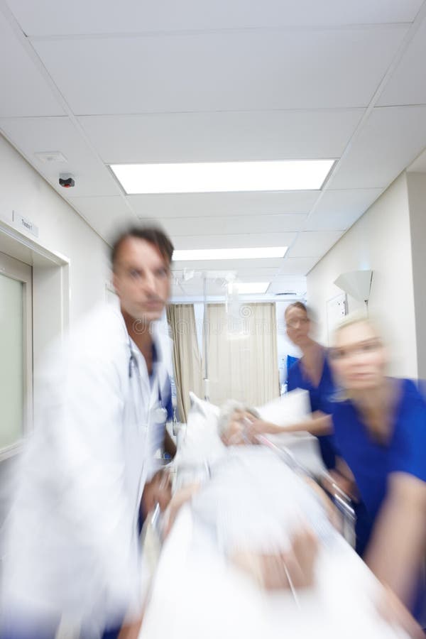 We Must Act Quickly. a Group of Doctors Rushing a Patient Down the ...