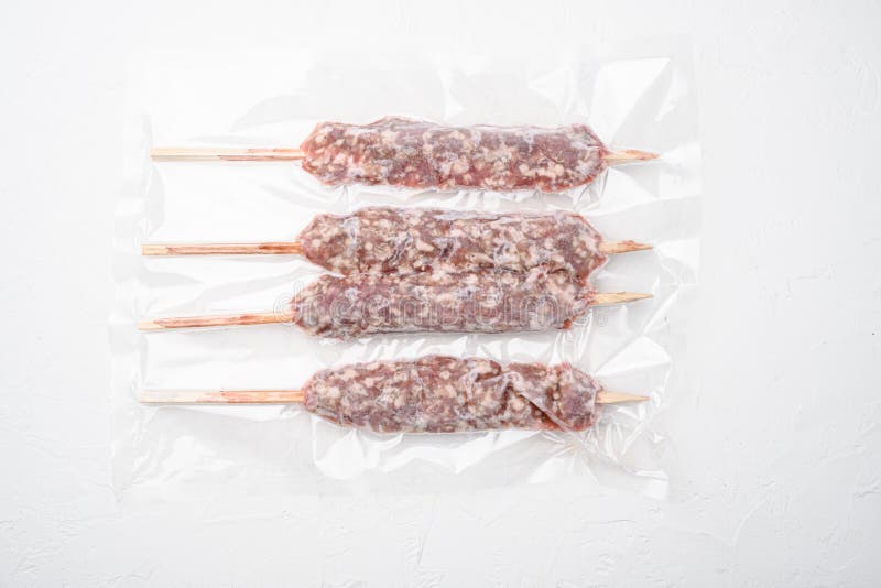 Mutton Minced Meat on Skewers in Vacuum Pack, on White Stone Table ...