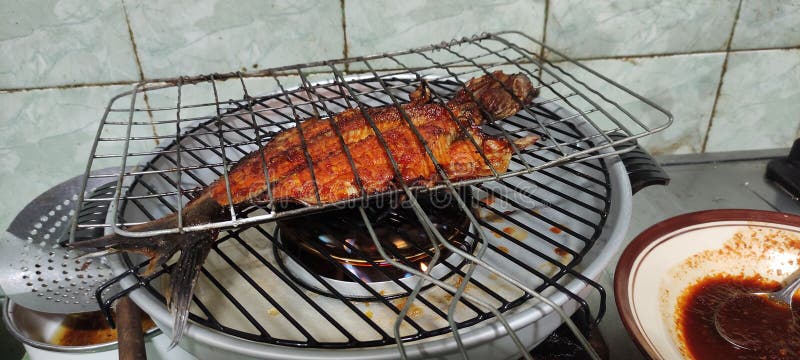 My Mom Cooking Patin Fish Using New Grill Stock Image - Image of patin ...