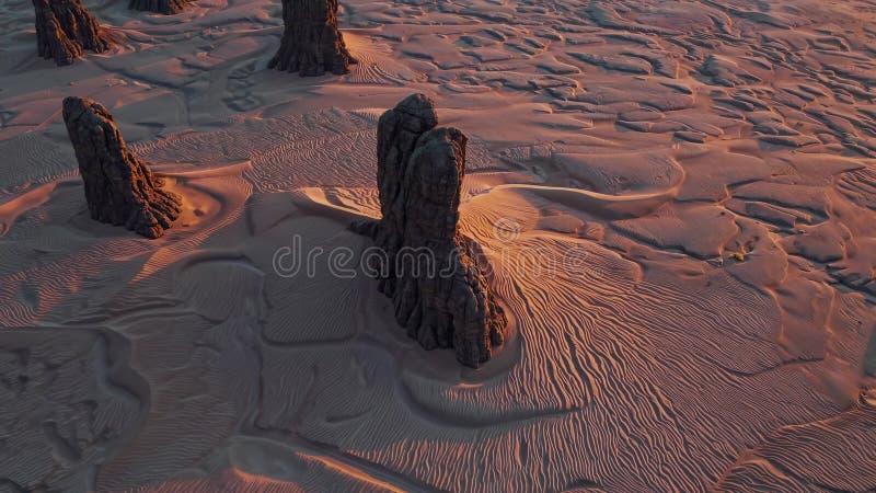 Mysterious Stone Pillars Cast Long Shadows on Textured Sand Symbolizing ...