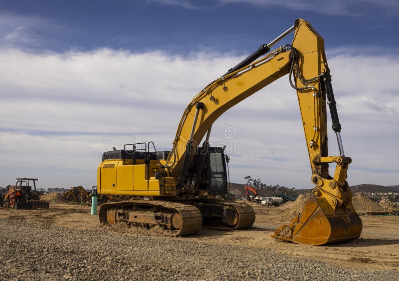N Excavator with Digging Bucket Against a Blue Sky with Clouds. Stock ...