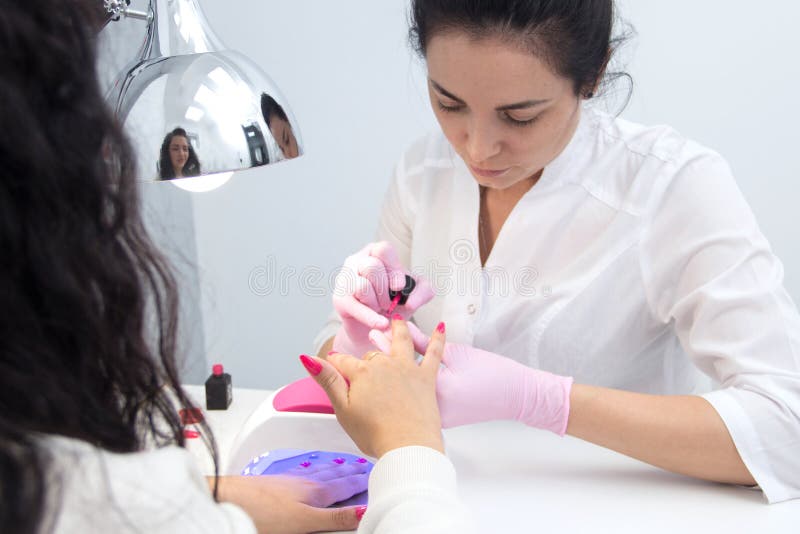 Nail Salon. Manicurist at Work. Manicure Process. Pro at Work with Her ...