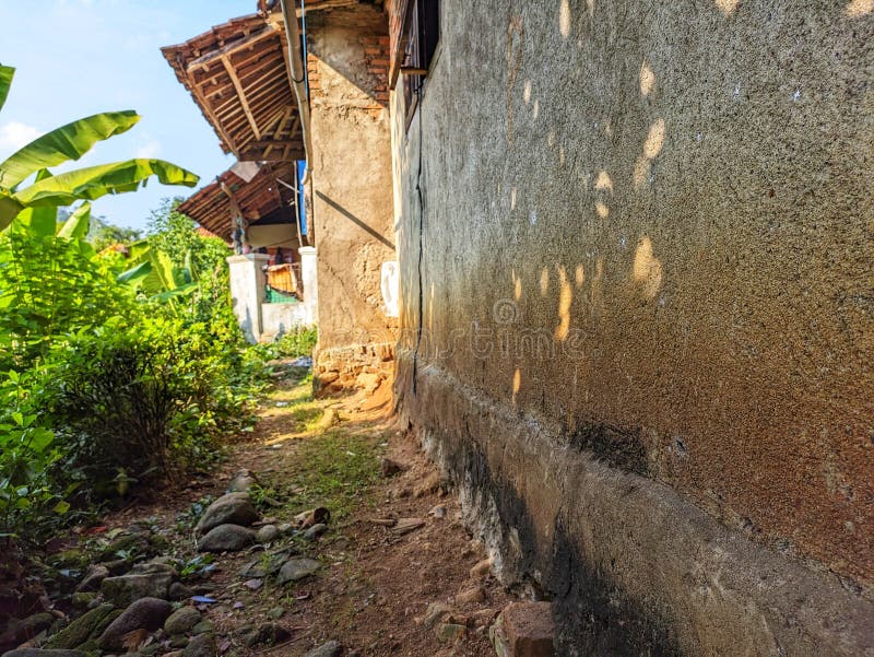 A Narrow Dirt Pathway Runs Alongside an Old Rustic House with a ...