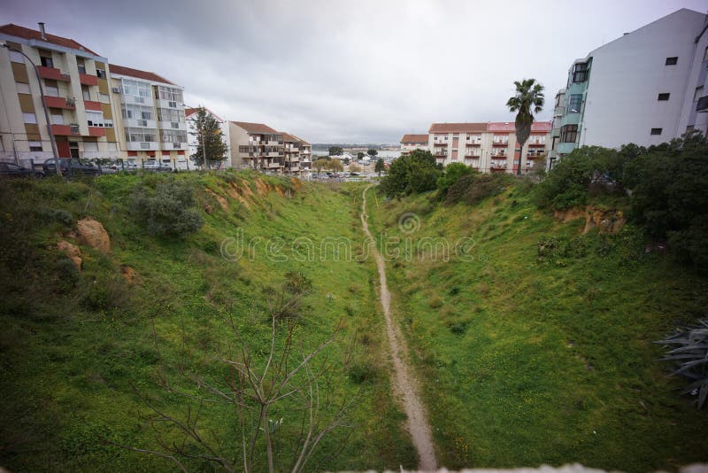 Narrow Path between Green Field Surrounded by Buildings Stock Photo ...