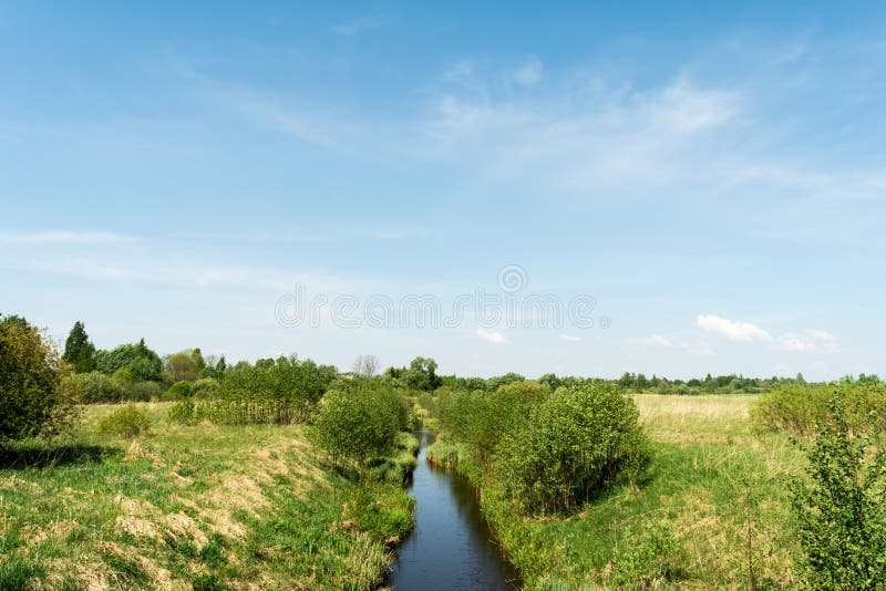 Narrow River Flows through a Field with Trees To the Horizon, a ...