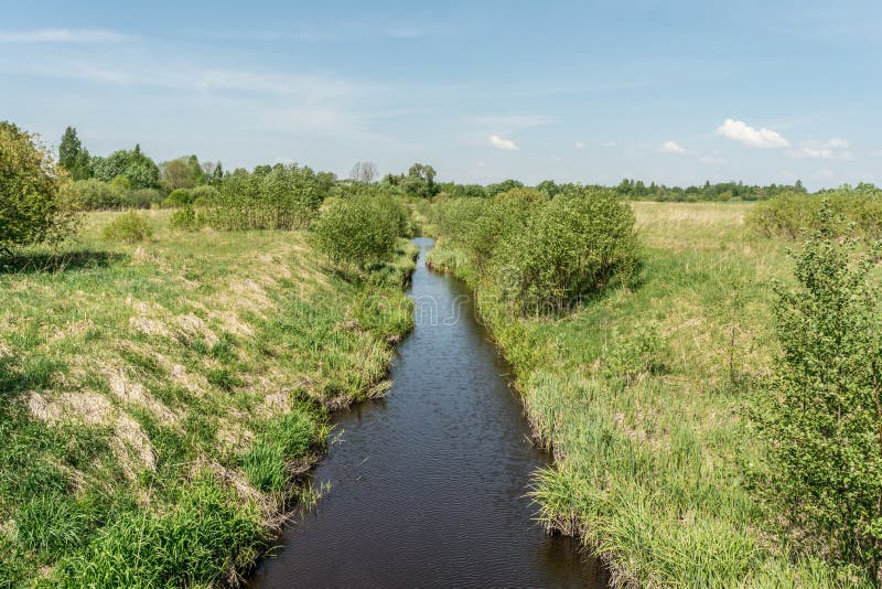 Narrow River Flows through a Field with Trees To the Horizon, a ...