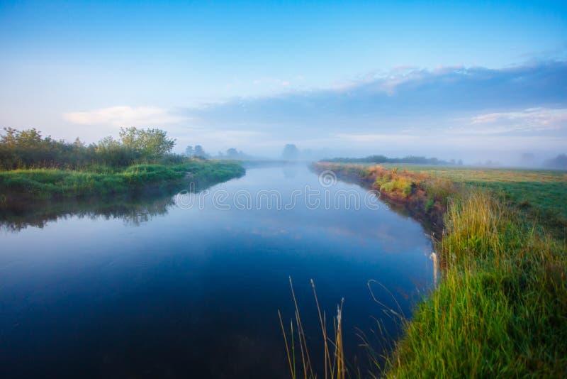A Narrow River Flowing Flanked by Greenery on Either Side. Stock Photo ...