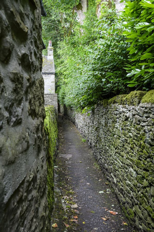 Narrow Stone Pathway Surrounded by Lush Greenery and Old Walls Stock ...