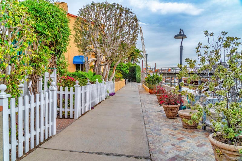Narrow Walkway in Front of Homes Lined with Potted Plants Trees and ... Narrow Walkway in Front of Homes Lined with Potted Plants Trees and ...