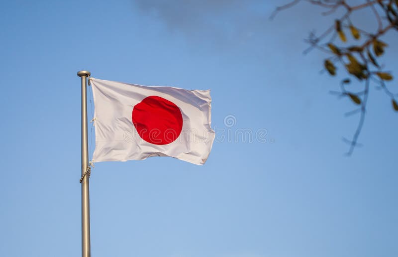 The National Flag of Japan Flies Against a Blue Sky Background Stock ...