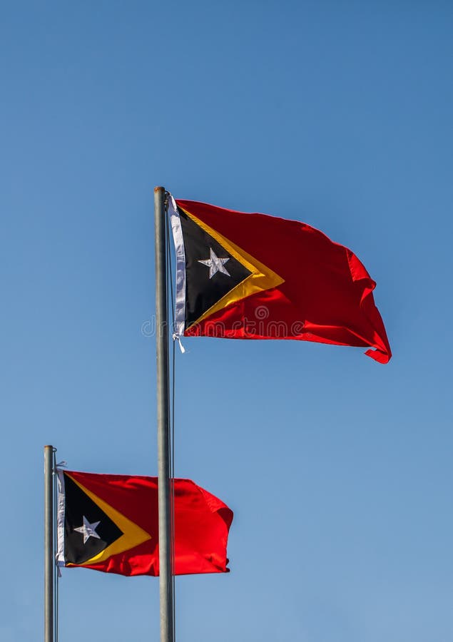 The National Flag of Timor Leste Flies Against a Blue Sky Background ...