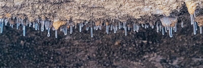 Natural Ice Stalactites Hanging from Rocky Ceiling in Winter Cave ...