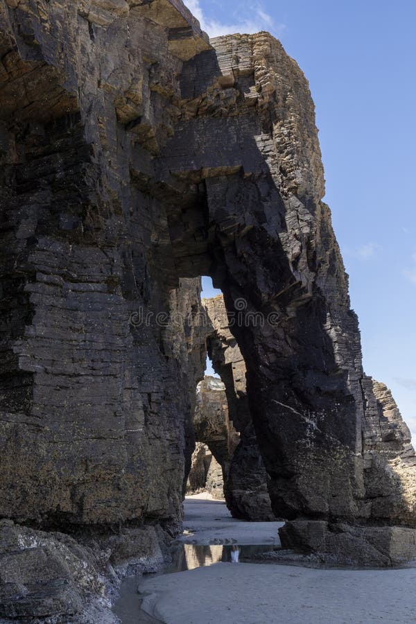 Natural Rock Arch Formations on a Sandy Beach with a Blue Sky ...