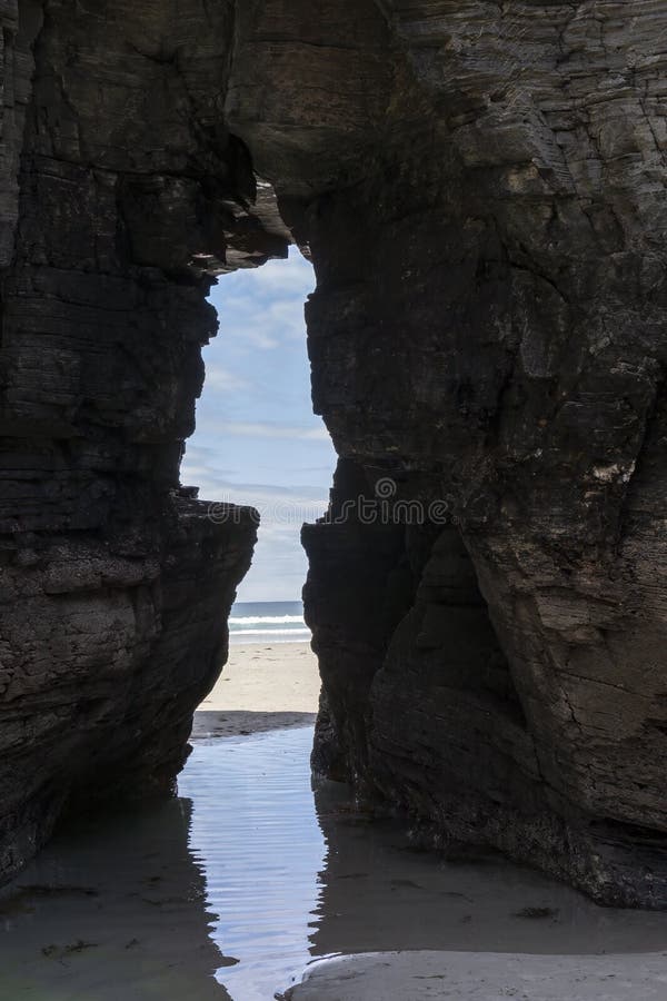 Natural Rock Passageway Leading To a Sandy Beach with Ocean Waves ...